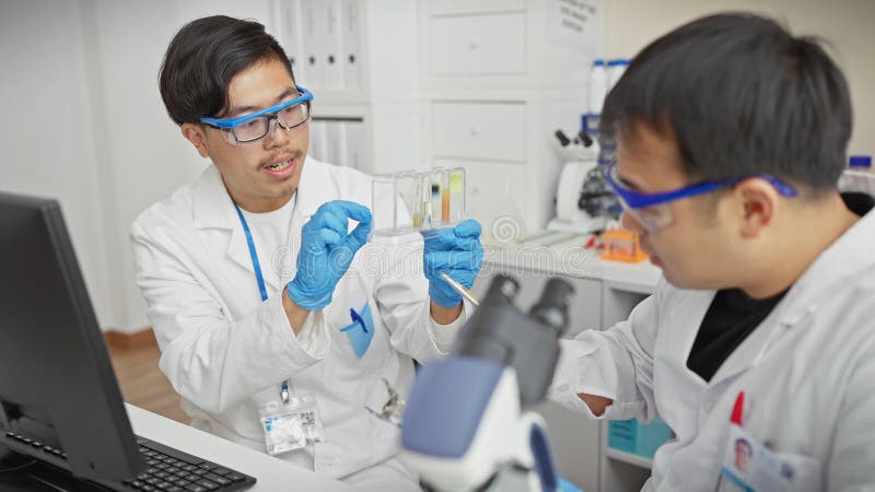 Two Men Analyze Samples in a Laboratory Setting, Wearing Lab Coats ...