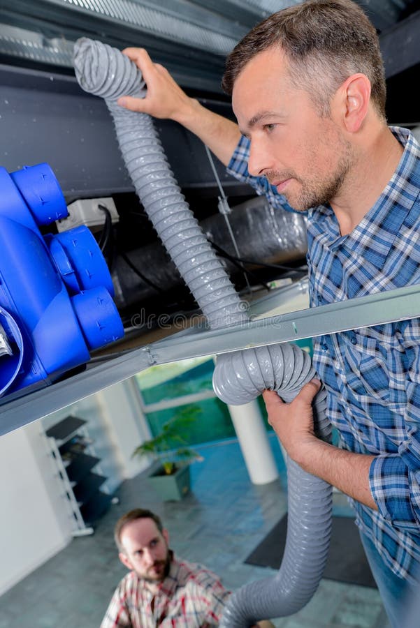 Two men assembling pipes stock image. Image of repair - 267513003