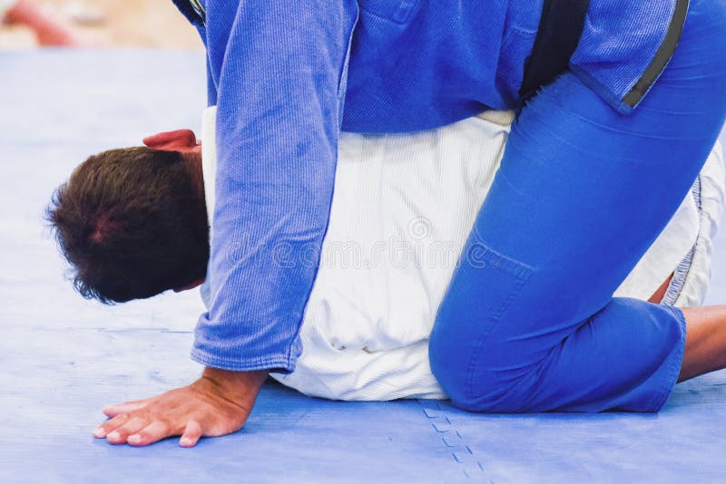 Two Unidentifiable Men Practicing Brazilian Jiu-Jitsu on a Blue Mat ...