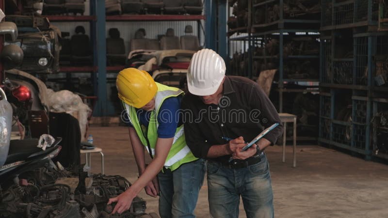 Two Men Checking Engine Parts in a Warehouse. with Both of Them Wearing ...