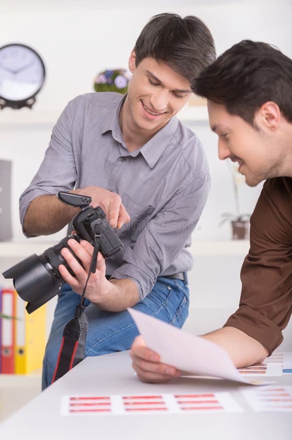 Two Men are Choosing a Photo from a Shoot. Stock Image - Image of ...