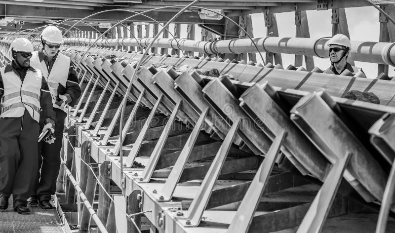 Two Men in Construction Uniforms Working on Some Pipe Construction ...