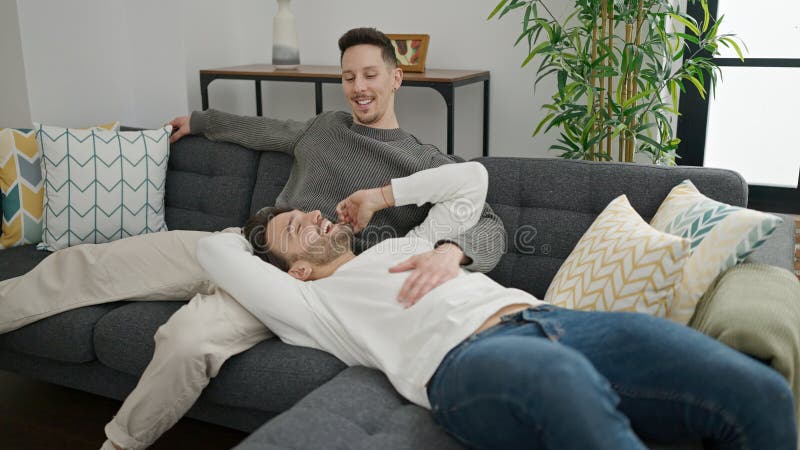Two Men Couple Hugging Each Other Sitting on Sofa at Home Stock Photo ...