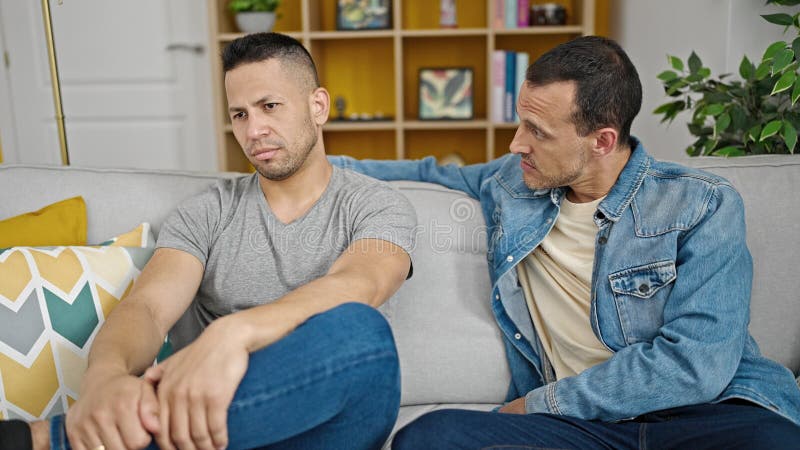 Two Men Couple Sitting on Sofa with Relaxed Expression at Home Stock ...