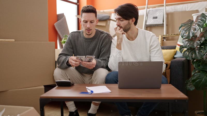 Two Men Couple Using Laptop Counting Dollars at New Home Stock Photo ...