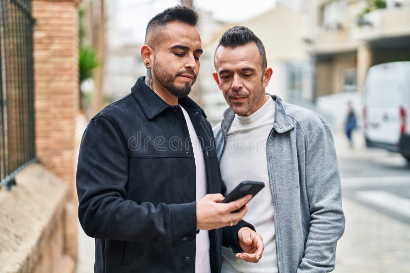 Two Men Couple Using Smartphone with Relaxed Expression at Street Stock ...