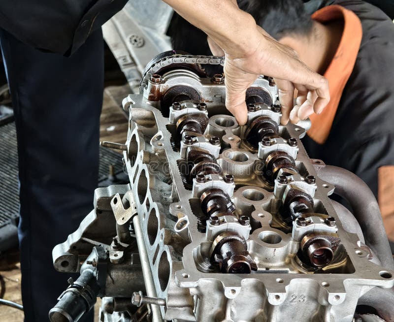 Two Men are Diligently Working on a Car Engine Inside a Garage Stock ...