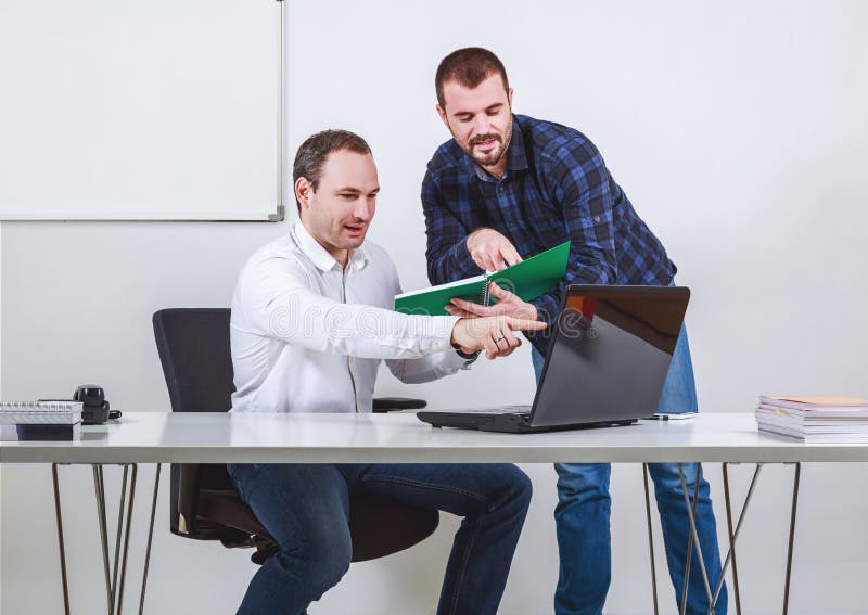 Two Men Discussing and Pointing at Computer and Note Book Stock Image ...