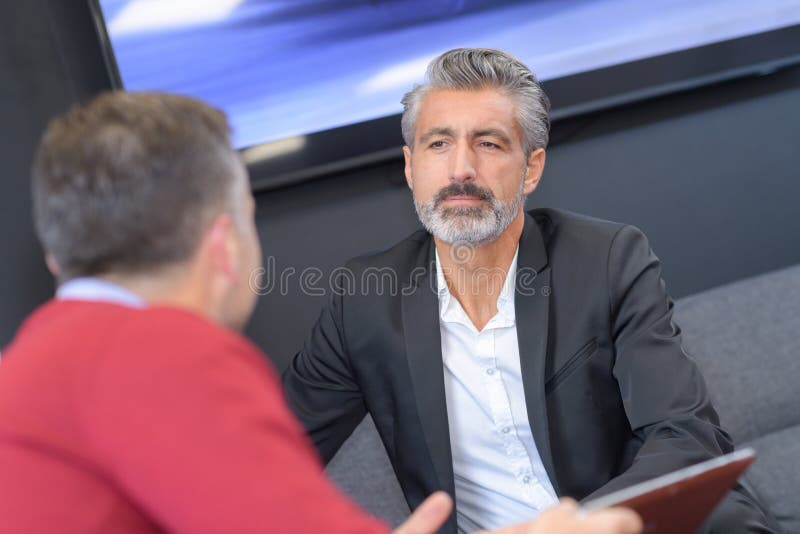 Two men in discussion stock image. Image of comfort - 132195867