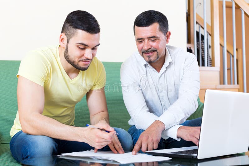 Two men with documents stock photo. Image of laptop, indoors - 80645100