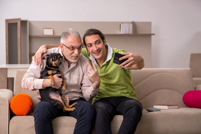 Two men with dog at home stock photo. Image of horns - 214026848