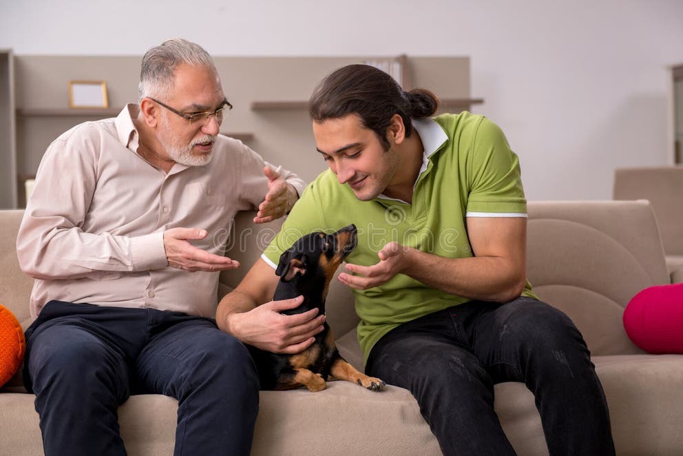 Two men with dog at home stock image. Image of owner - 222540917