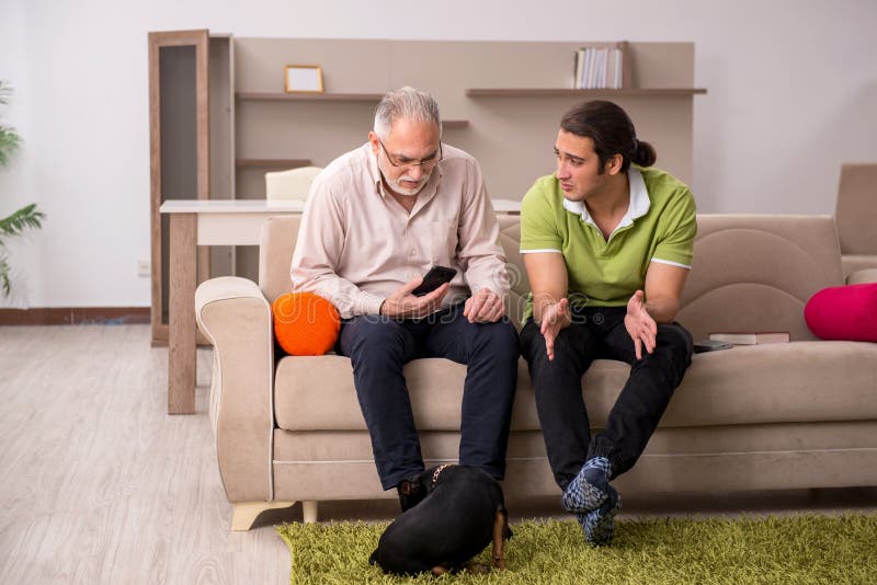 Two men with dog at home stock image. Image of phone - 239759543