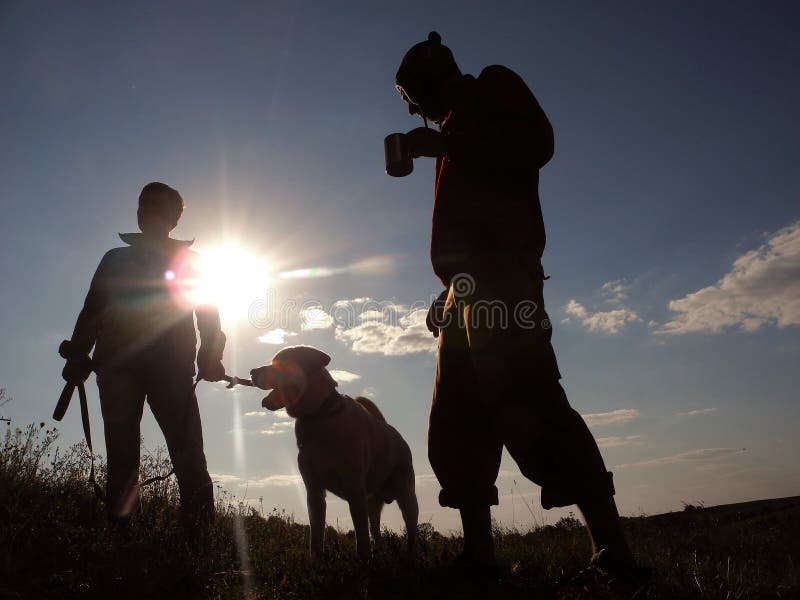 Two Men and a Dog in the Sunset Stock Image - Image of sunset, season ...
