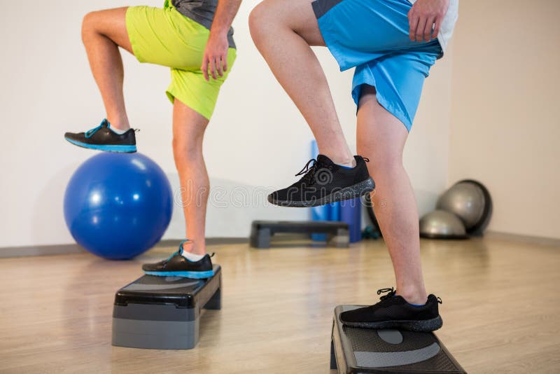 Two Men Doing Step Aerobic Exercise on Stepper Stock Image - Image of ...