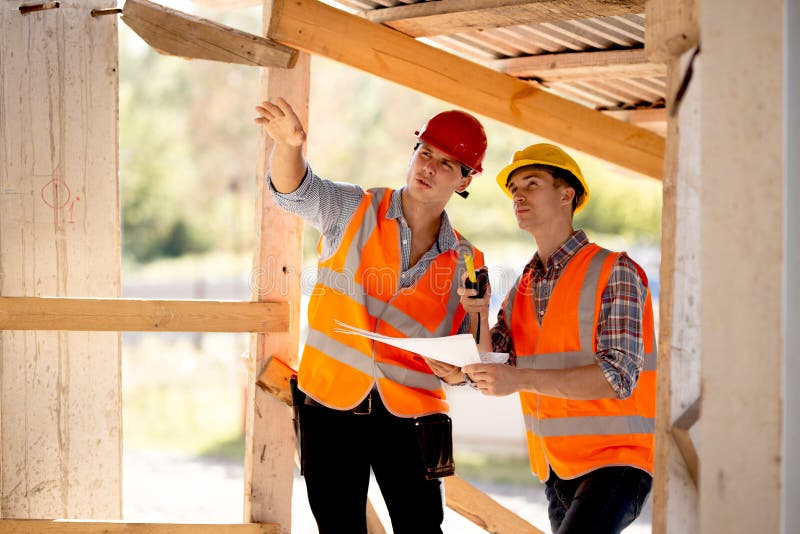 Two Men Dressed in Shirts, Orange Work Vests and Helmets Explore ...