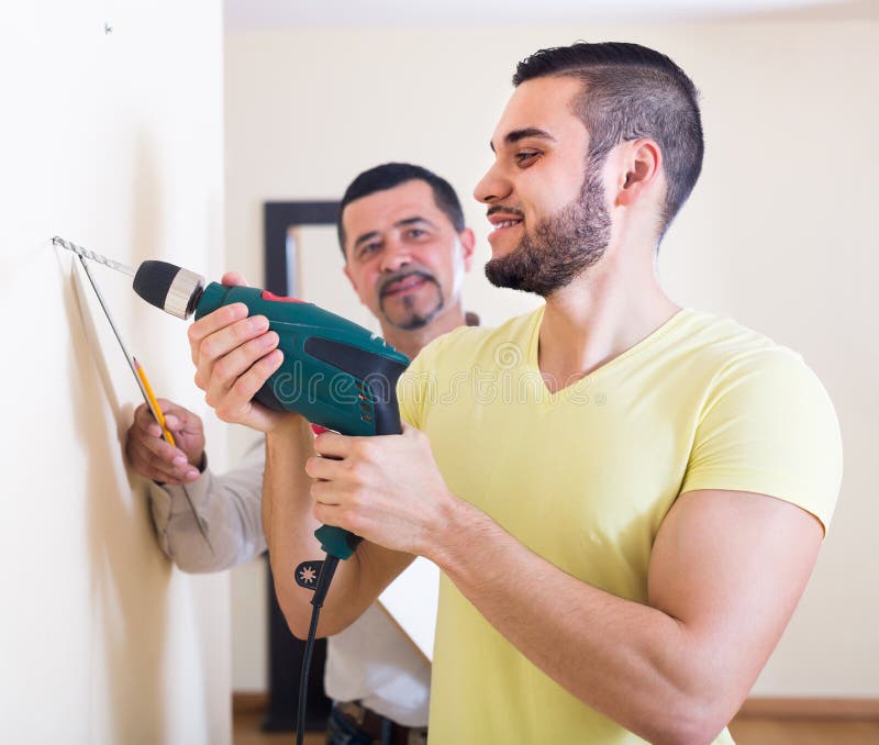 Two Men with Drill and Level Stock Image - Image of indoors, casual ...