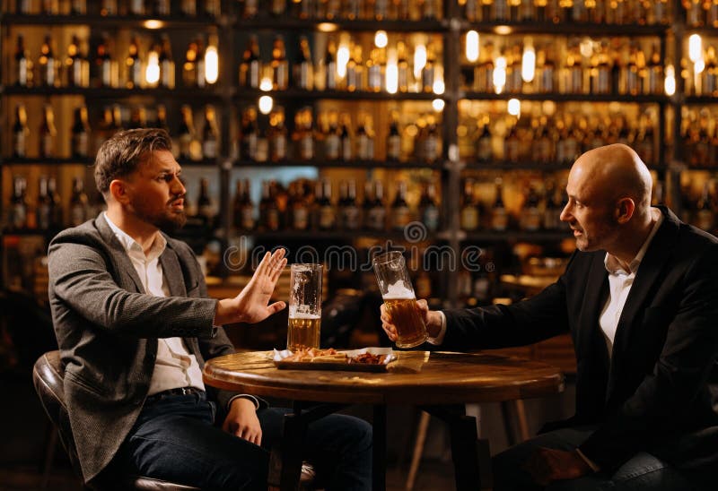 Two Men Engage in a Serious Conversation Over Drinks in a Bar Setting ...