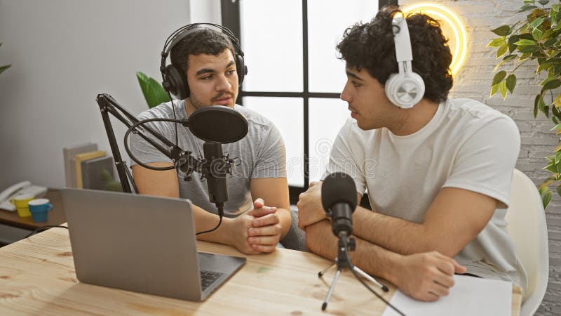 Two Men Engaged in Podcasting Indoors, Equipped with Microphone ...