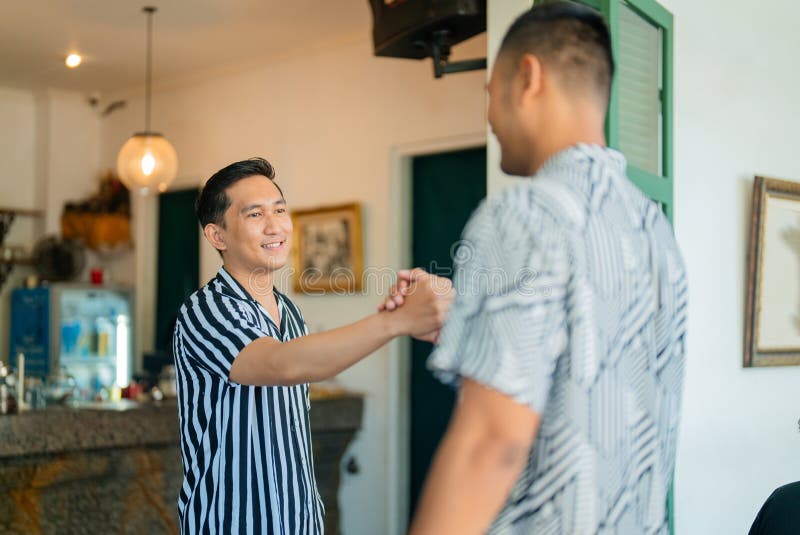 Two Men Engaging in a Handshake in a Bright, Modern, Contemporary Cafe ...