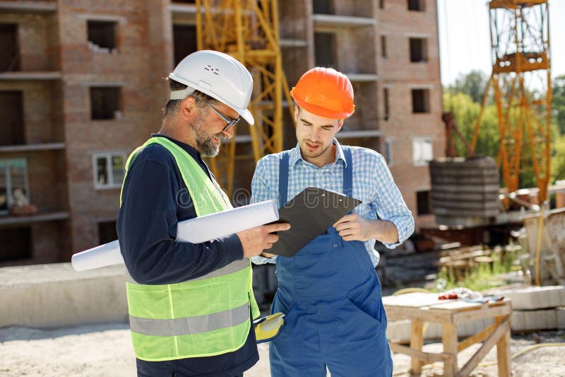 Two Men Engineers at a Construction Site are Looking at the Drawings ...