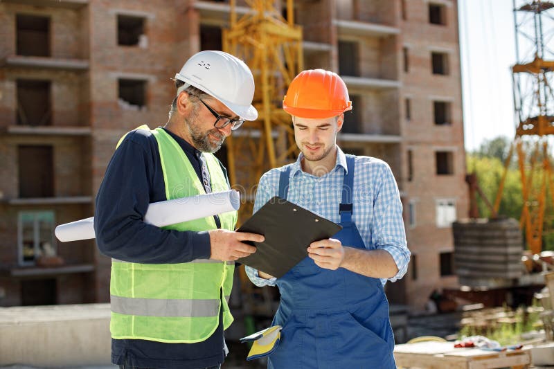 Two Men Engineers at a Construction Site are Looking at the Drawings ...