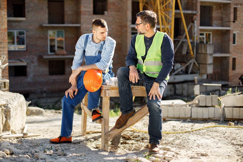 Two Men Engineers at a Construction Site are Looking at the Drawings ...