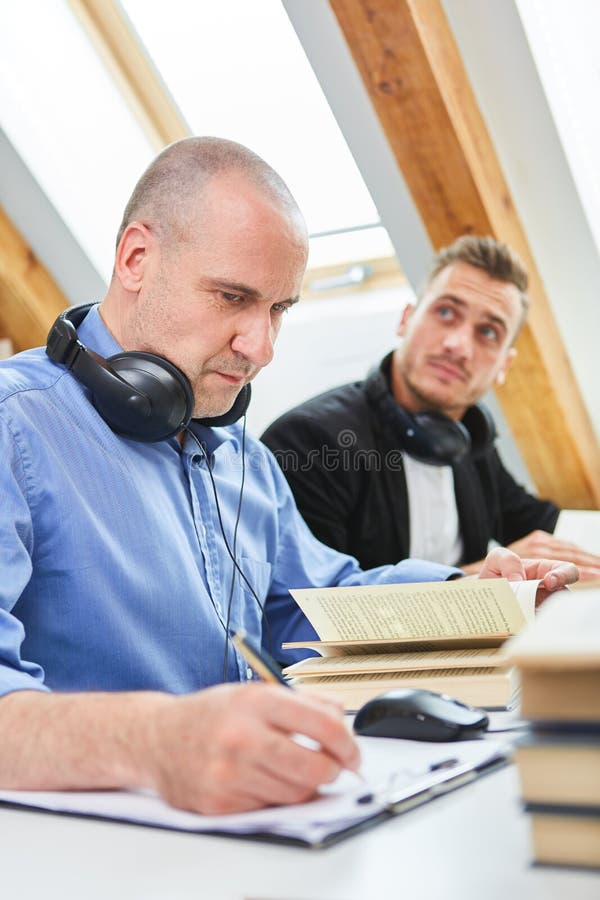 Two men in an exam or exam stock photo. Image of college - 179270798