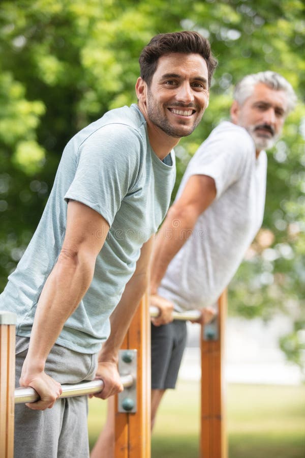 Two Men Exercising on Bars in Modern Fitness Park Stock Photo - Image ...