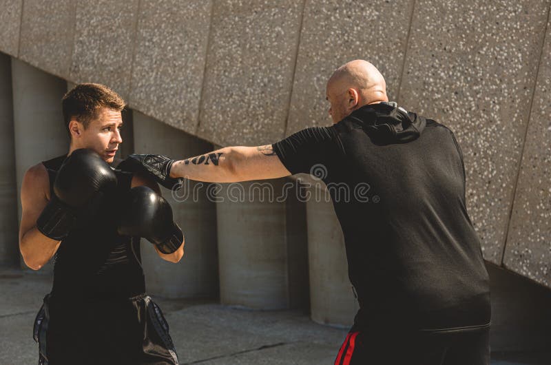 Two Men Exercising and Fighting in Outside. Boxer in Gloves is Training ...