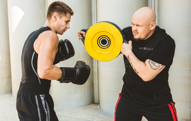Two Men Exercising and Fighting in Outside. Boxer in Gloves is Training ...
