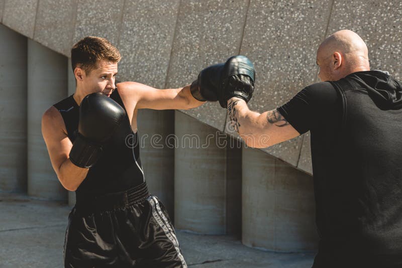 Two Men Exercising and Fighting in Outside. Boxer in Gloves is Training ...
