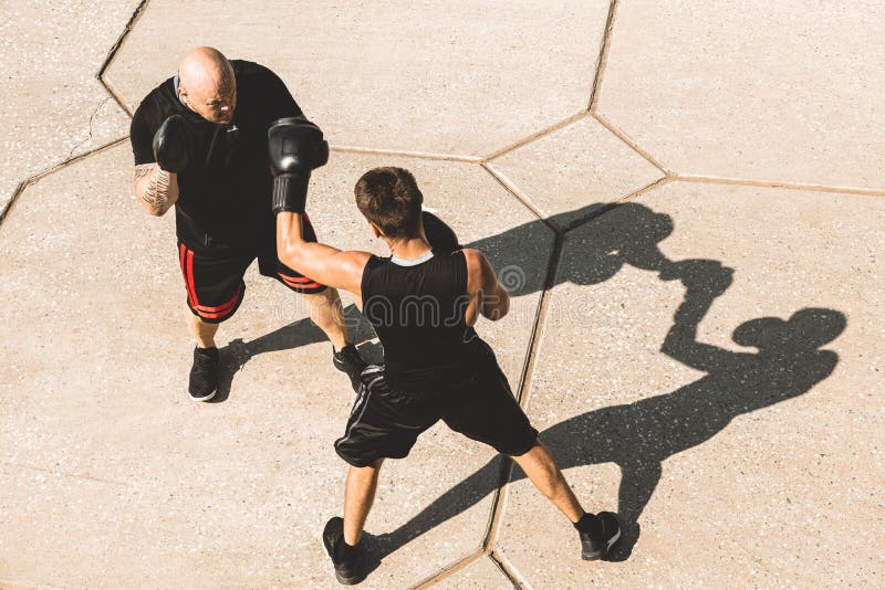 Two Men Exercising and Fighting in Outside. Boxer in Gloves is Training ...
