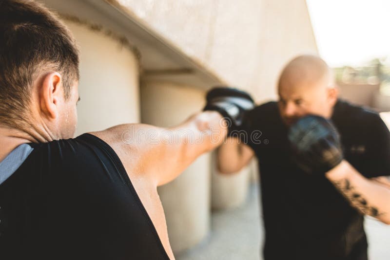 Two Men Exercising and Fighting in Outside. Boxer in Gloves is Training ...