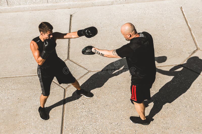 Two Men Exercising and Fighting in Outside. Boxer in Gloves is Training ...
