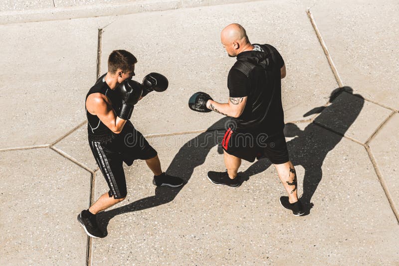 Two Men Exercising and Fighting in Outside. Boxer in Gloves is Training ...