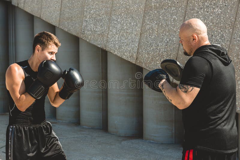 Two Men Exercising and Fighting in Outside. Boxer in Gloves is Training ...