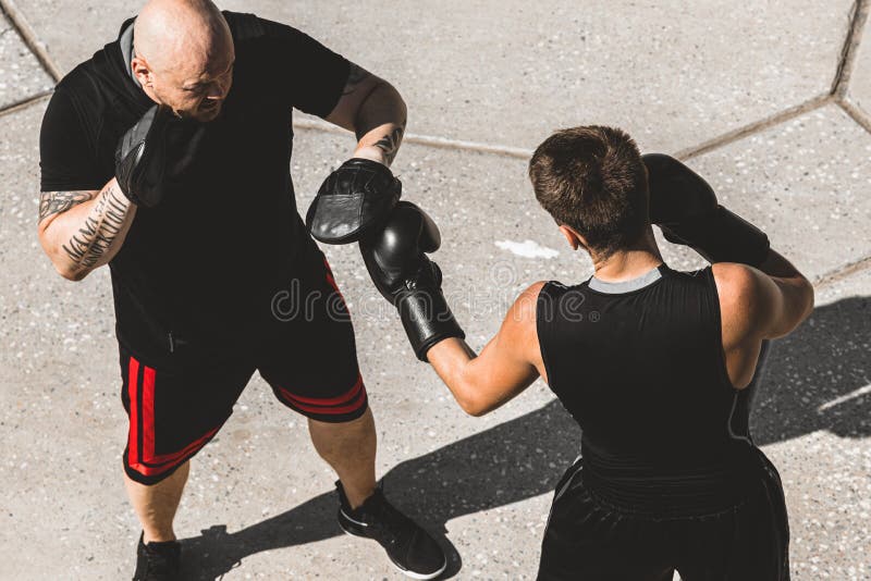 Two Men Exercising and Fighting in Outside. Boxer in Gloves is Training ...