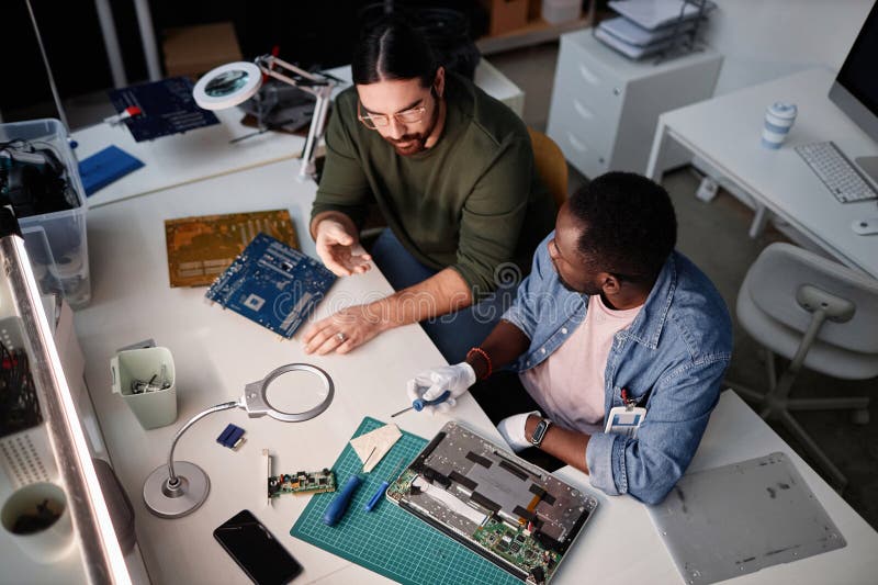 Two men fixing electronics stock image. Image of build - 301112969