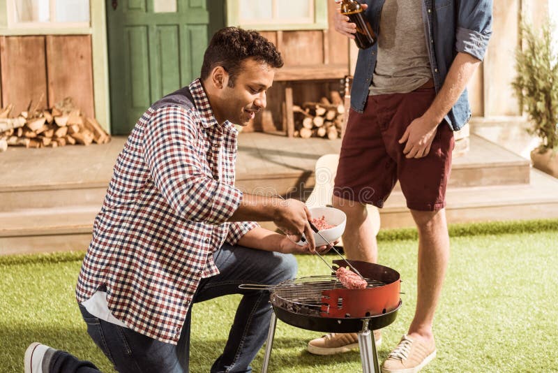 Two Men Grilling Burgers while Drinking Beer Together Stock Photo ...