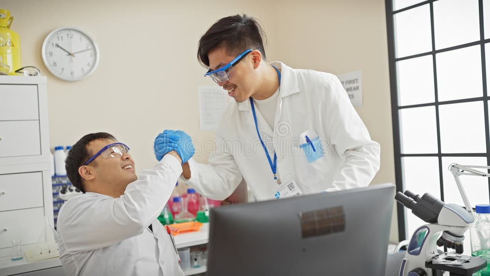 Two Men Handshake in a Laboratory Setting, Portraying a Sense of Teamwork and Scientific ...