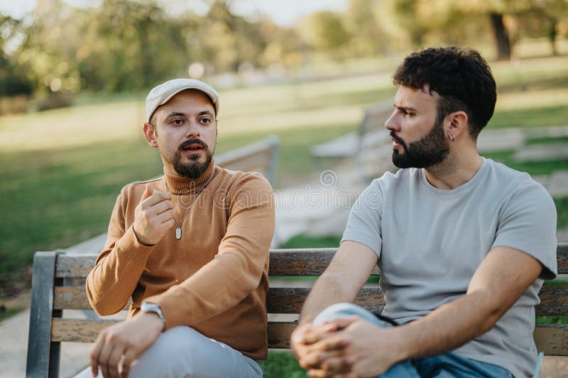 Two Men Having a Thoughtful Conversation on a Park Bench Outdoors Stock ...