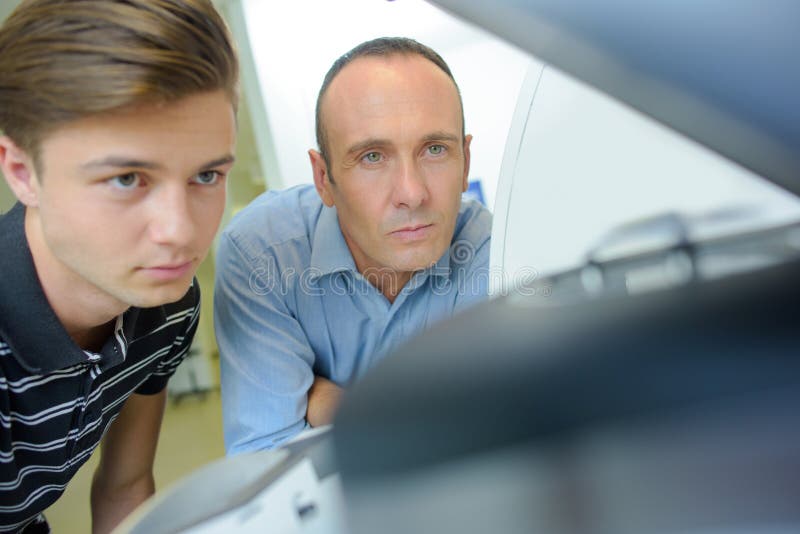 Two Men Intently Watching Appliance Stock Image - Image of male ...