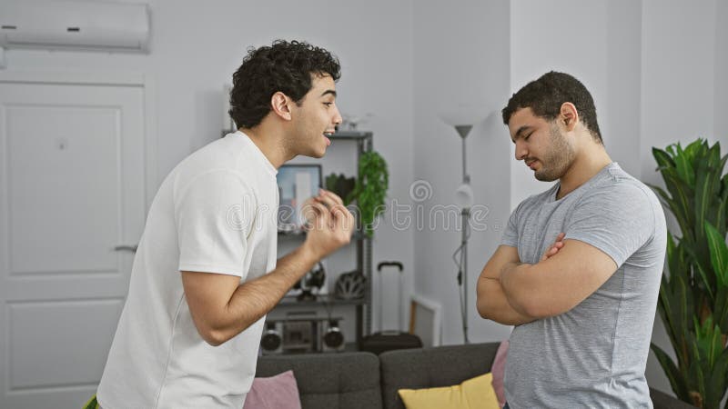 Two Men Interact in a Modern Living Room, One Gesturing ...