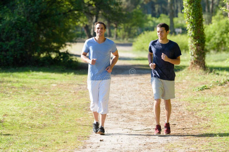 Two men jogging in park stock image. Image of action - 161830825