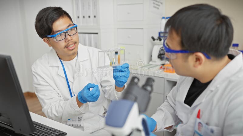 Two Men in Lab Coats Analyze Samples in a Science Laboratory with ...