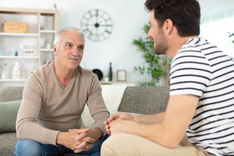 Two Men in Living Room Talking and Smiling Stock Image - Image of ...