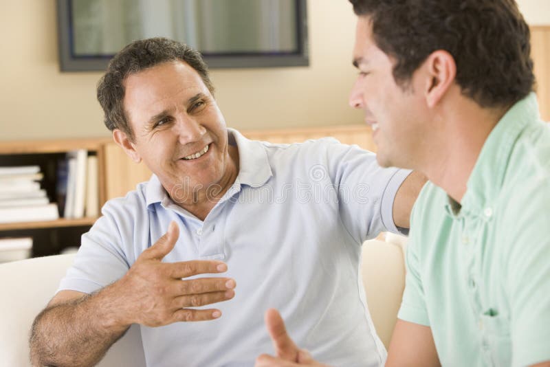 Two Men in Living Room Talking and Smiling Stock Image - Image of ...