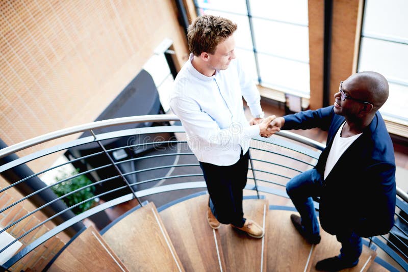 Two Men in Modern Office Building Shaking Hands and Smiling Stock Photo ...