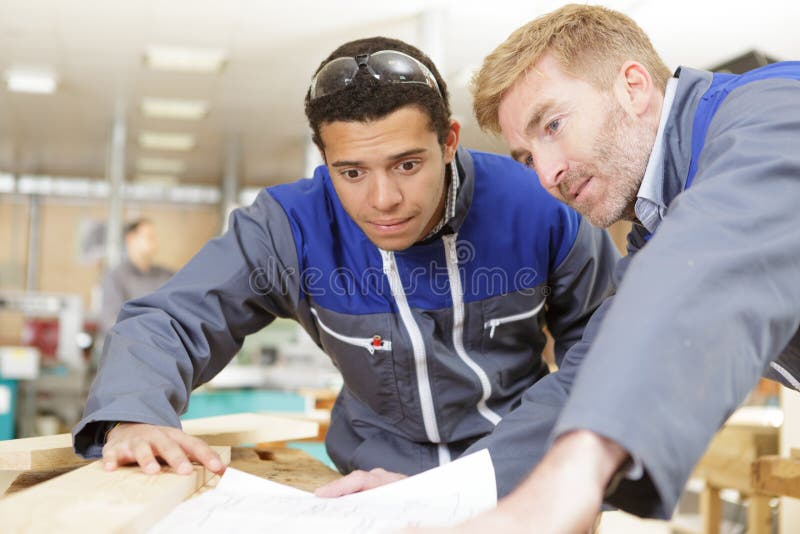 Two Men Operating Machine in Wood Workshop Stock Image - Image of ...